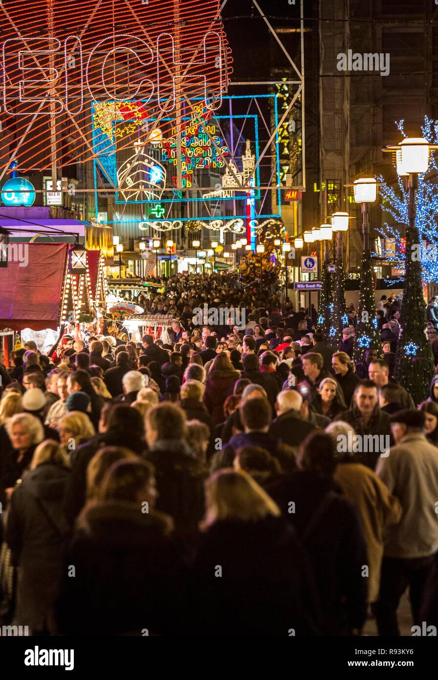 Crowds thronging between stores and Christmas market stalls, pedestrian ...