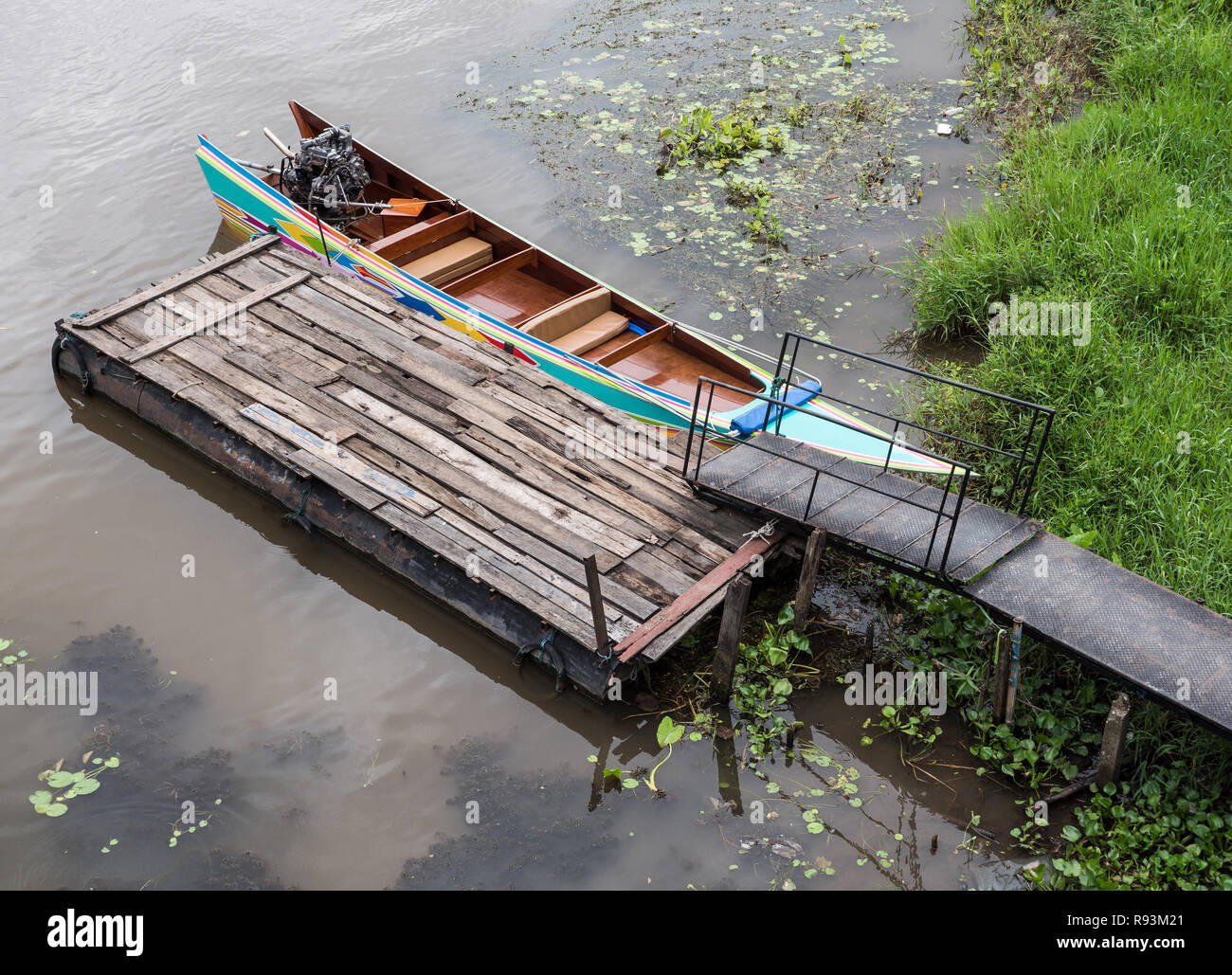 Traditional long tail boat in Thai style is floating near the wooden ...