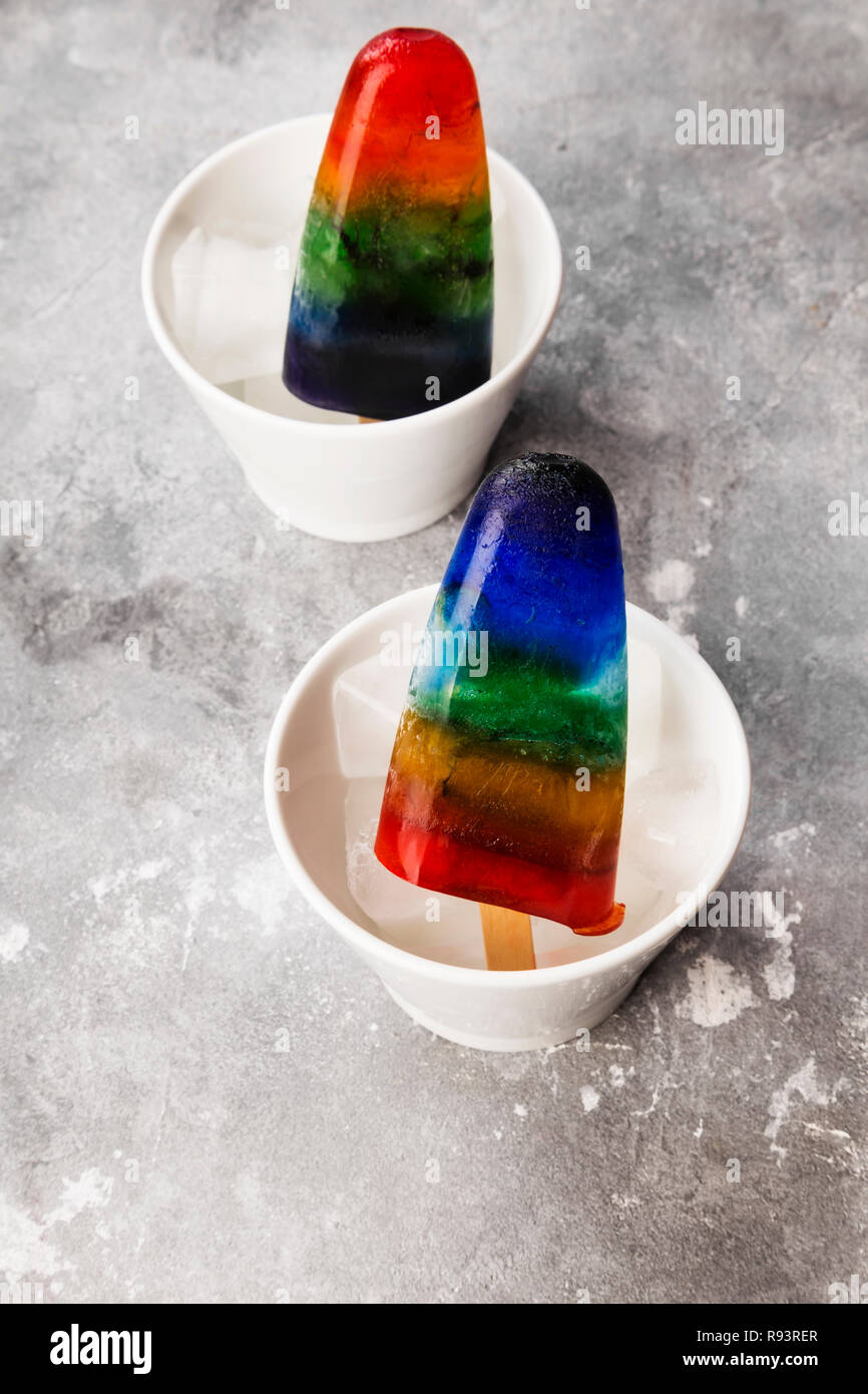 Rainbow colorful ice cream popsicle with wood stick in white bowls on ...