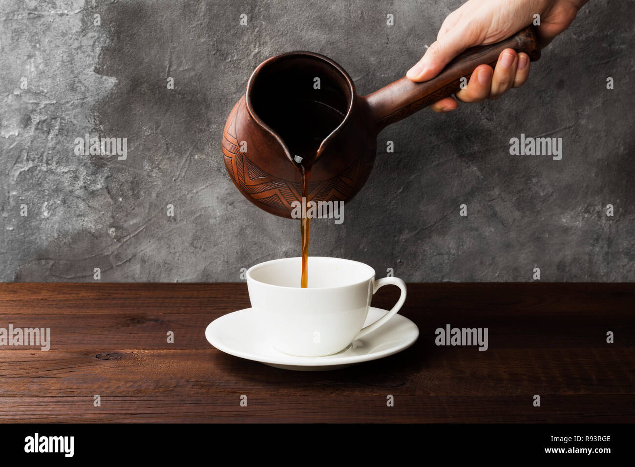 Coffee in white cup and clay cezve on wooden background Stock Photo - Alamy