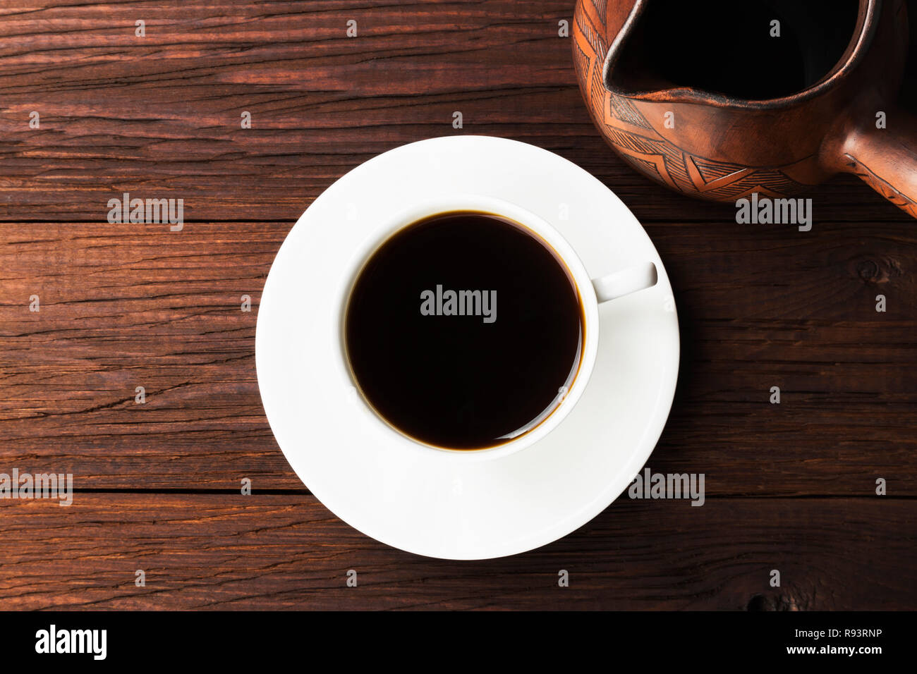 Coffee in white cup and clay cezve on wooden background. Top view. Food ...