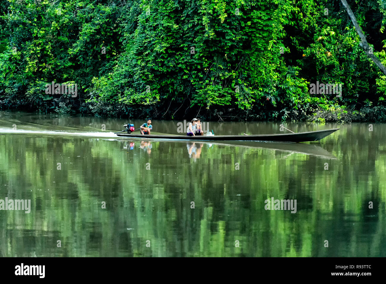 Locals cruising on the Amazon River in a dugout canoe Stock Photo - Alamy