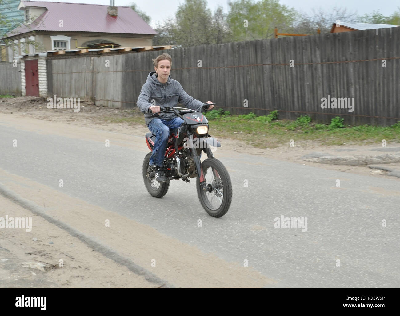 Kovrov, Russia. 1 May 2012. Teen riding a motorcycle with one storey ...