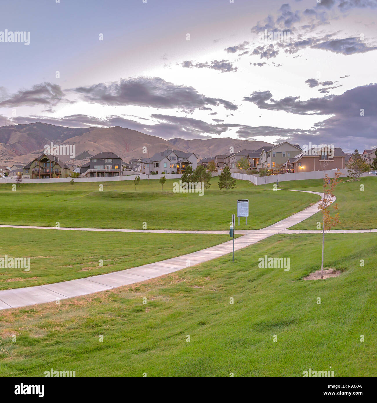 Pathway on lawn with homes and mountain background Stock Photo - Alamy