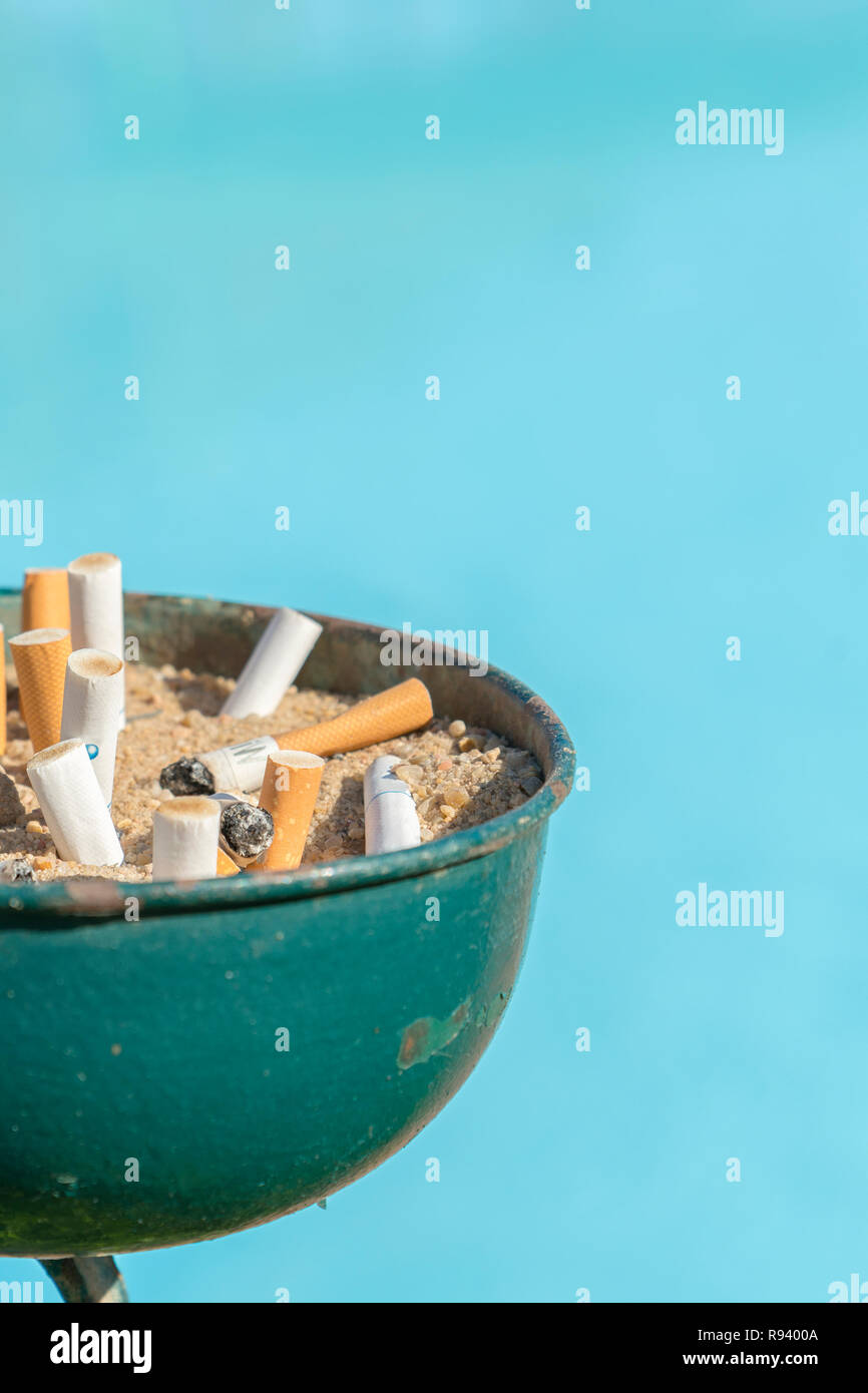 Cigarette butts in the urn. Cigarette disposal urn full of cigarettes ...