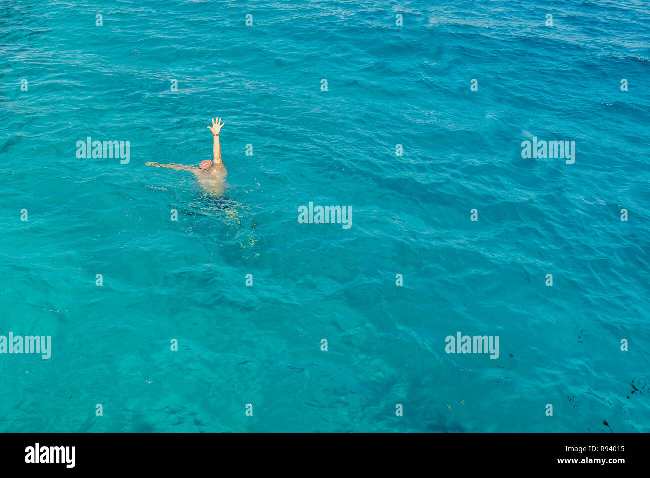 Drowning man in sea asking for help with raised arms. The man is ...