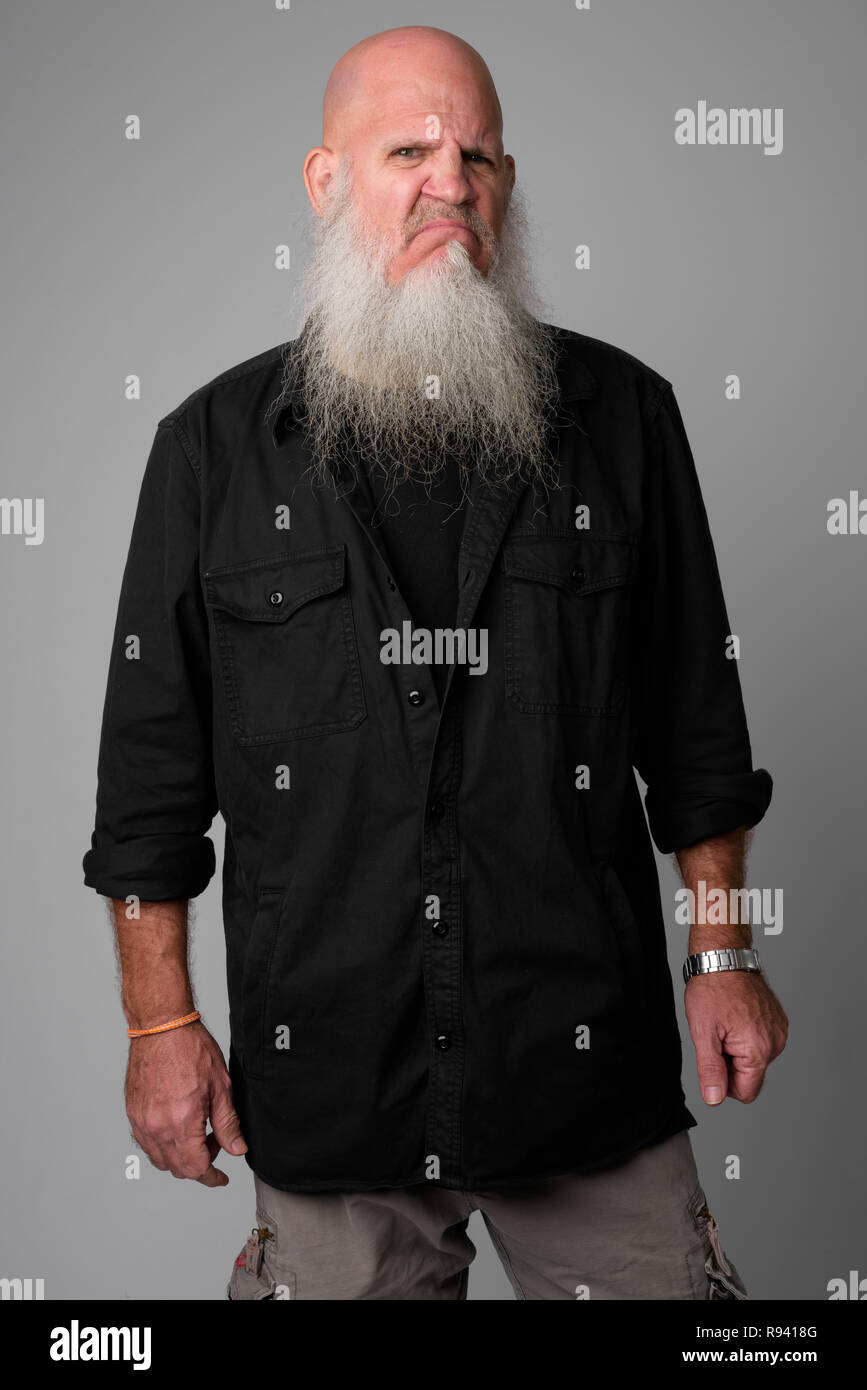 Studio shot of mature bald bearded man looking angry Stock Photo - Alamy