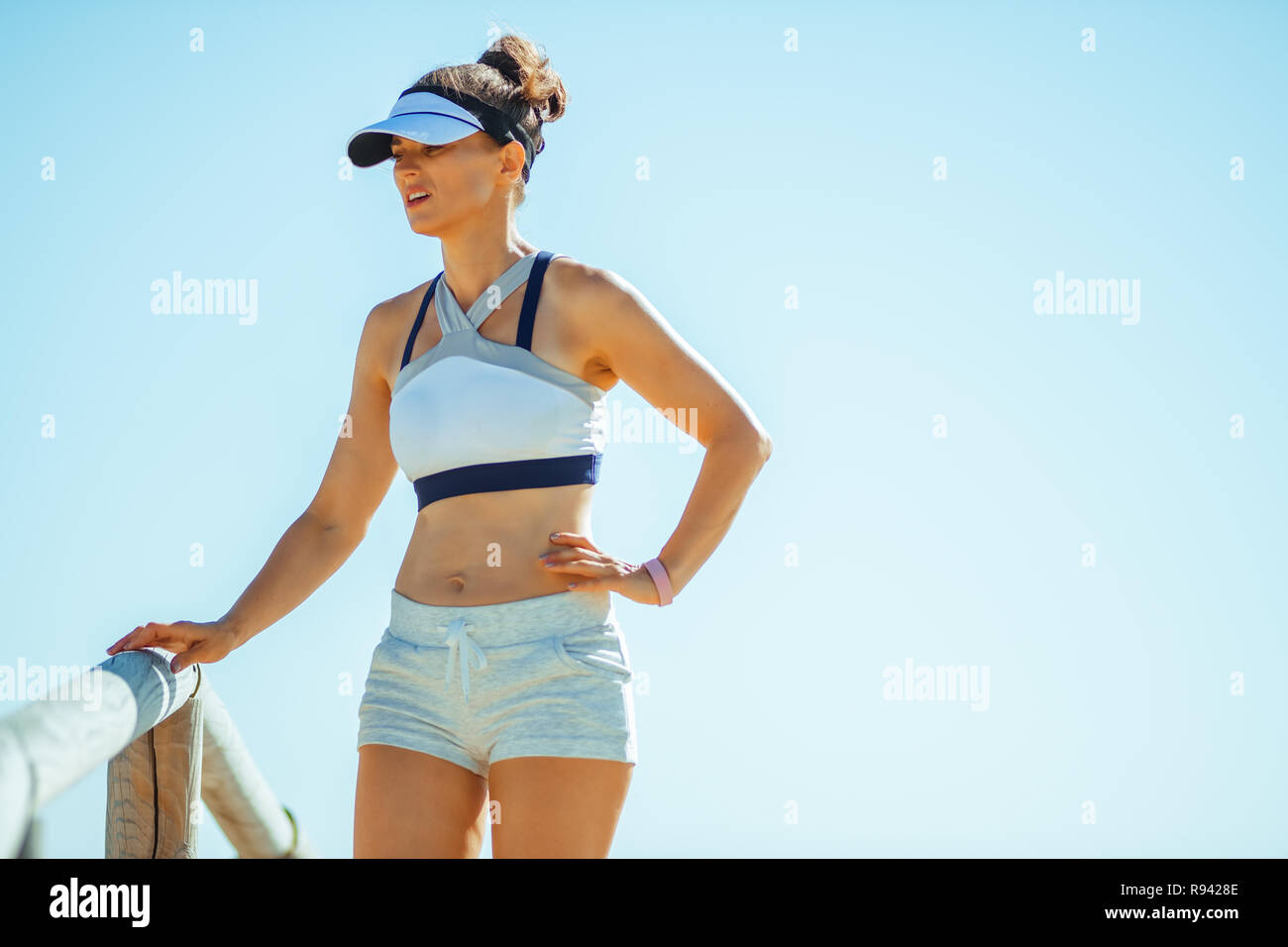 active woman jogger in fitness clothes on the beach catching breath ...