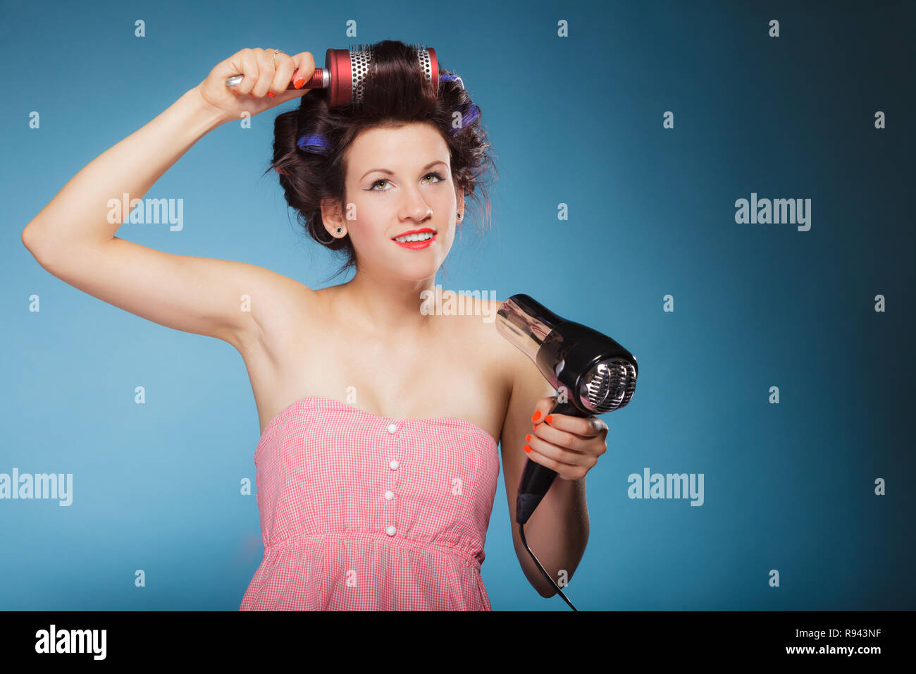 Young woman preparing to party having fun, funny girl styling hair with ...