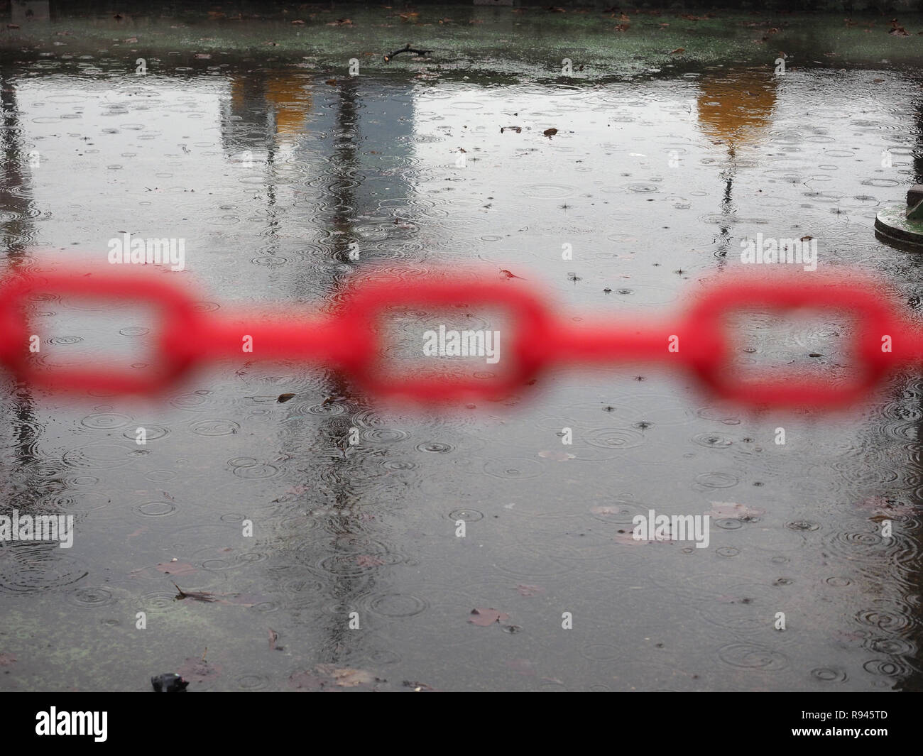red plastic chain out of focus, focus on rain puddle Stock Photo - Alamy