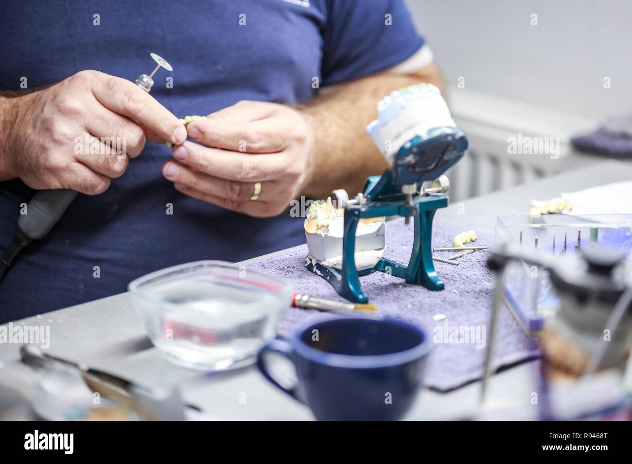 Dental technician working with articulator in dental laboratory ...