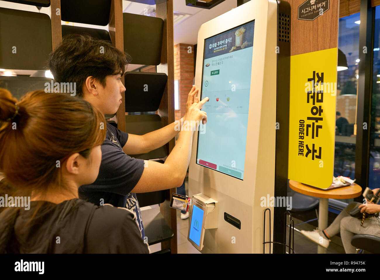 BUSAN, SOUTH KOREA - CIRCA MAY, 2017: people use ordering kiosk at ...