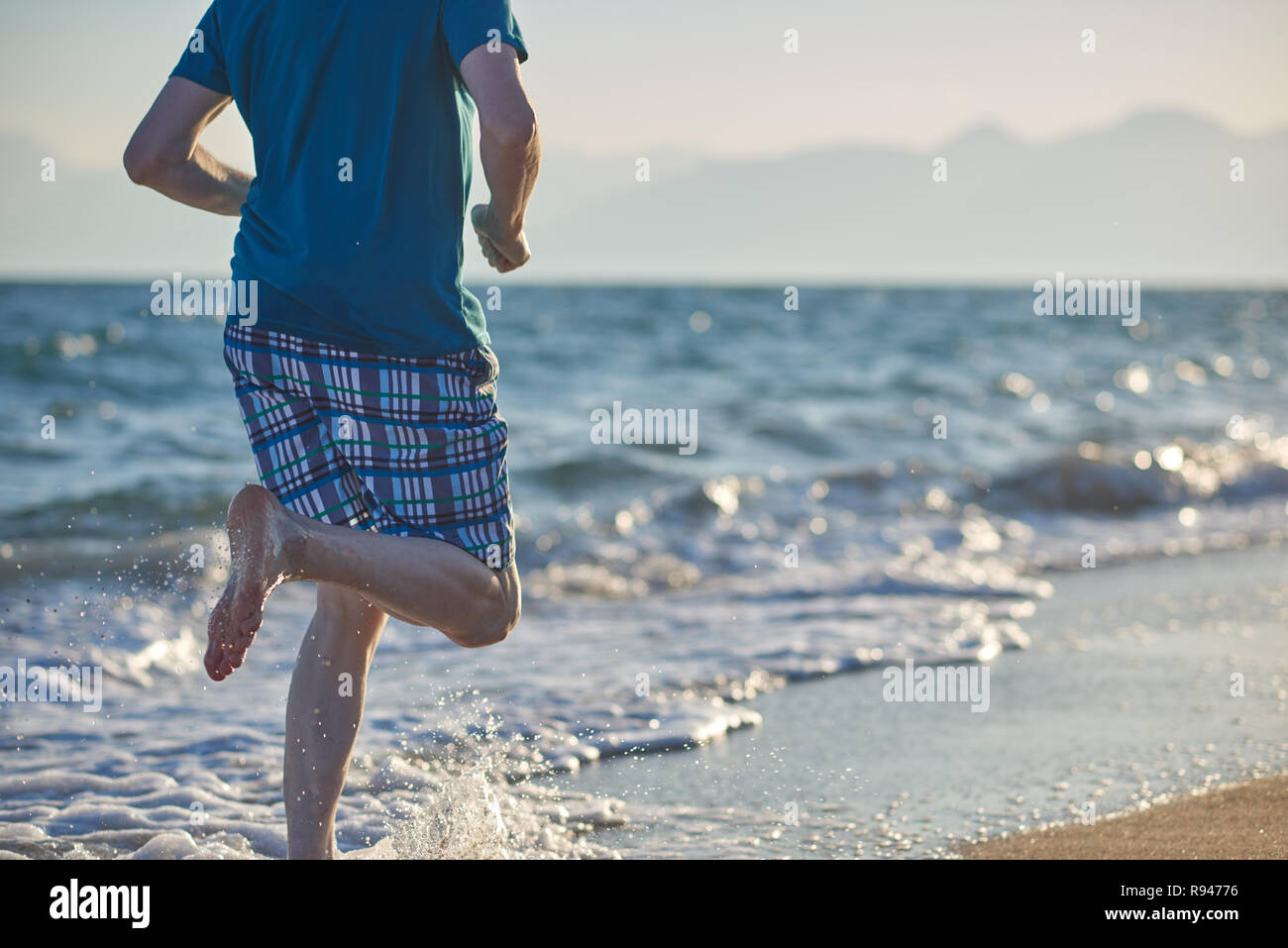 Barefoot mature man during jogging on a beach Stock Photo - Alamy