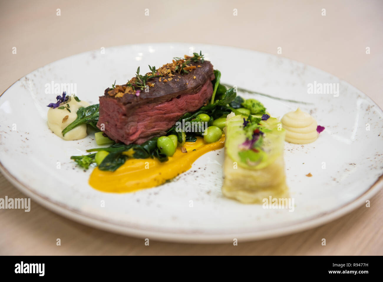 Beef meat with green peas, sweet potato mousse, roasted spinach and ...