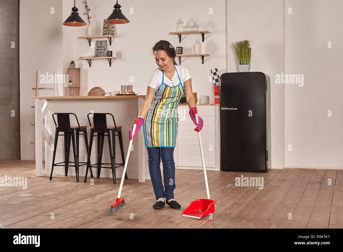 Cleaning concept. Young woman sweeping floor on the kitchen Stock Photo ...