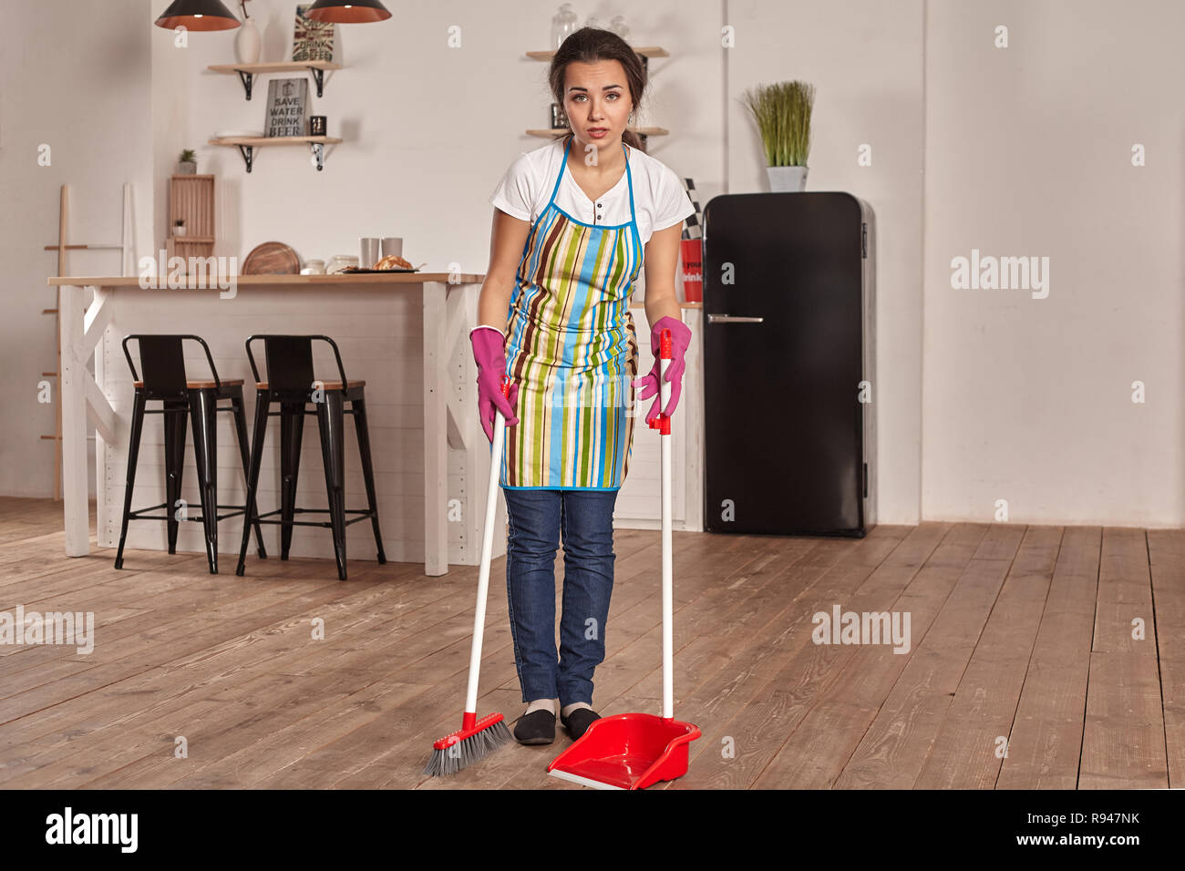 Cleaning concept. Young woman sweeping floor on the kitchen Stock Photo ...