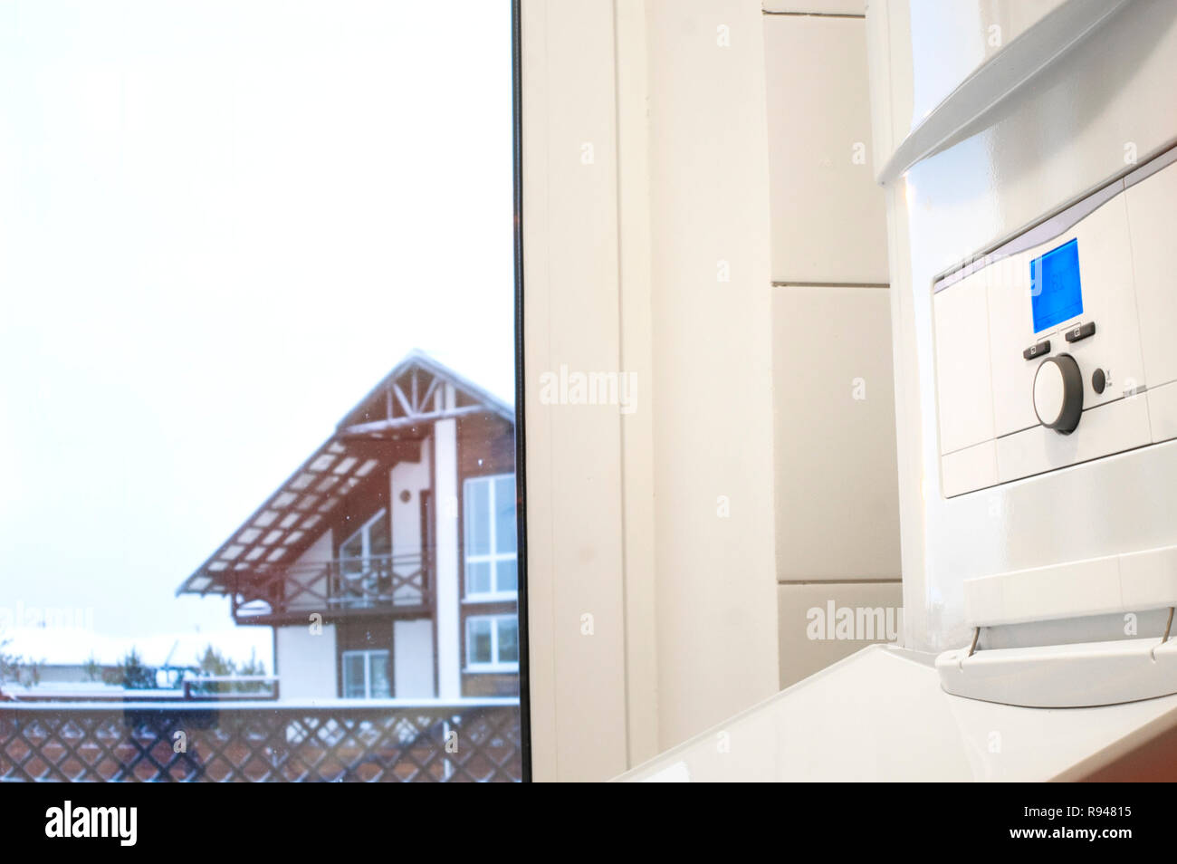 Close-up of a gas boiler and a winter town behind the window Stock ...
