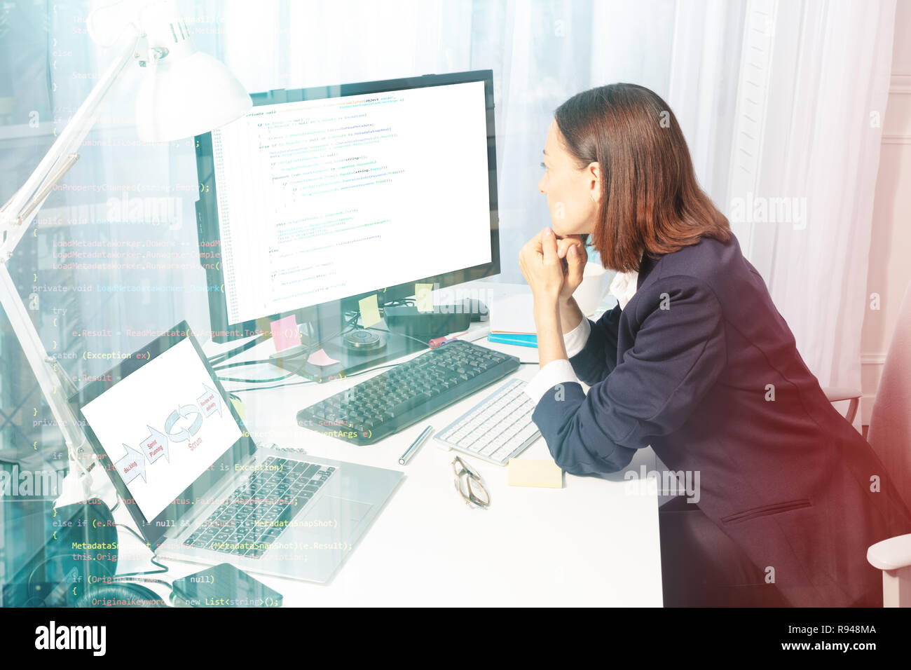 Portrait of woman in business suit looking at the screen of computer ...