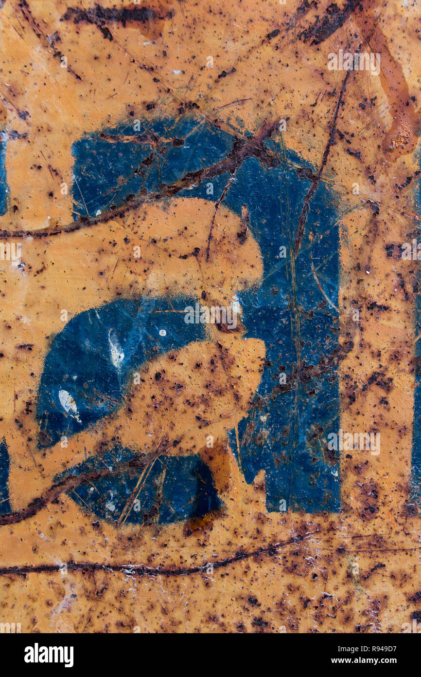 blue letter scratched rusty metal texture, blue stencil painted on ...