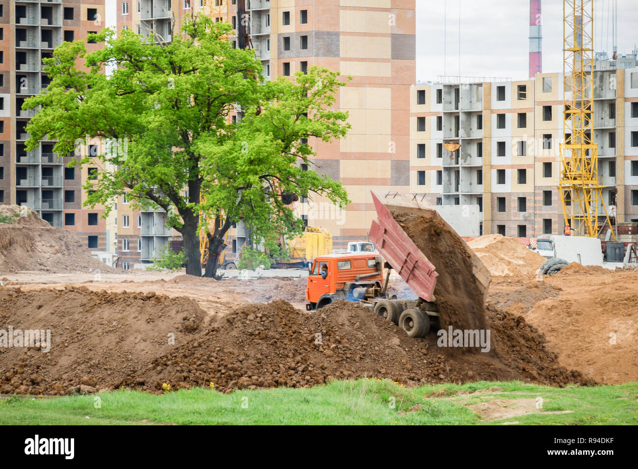 Dump truck unloads the ground. Construction site Stock Photo - Alamy