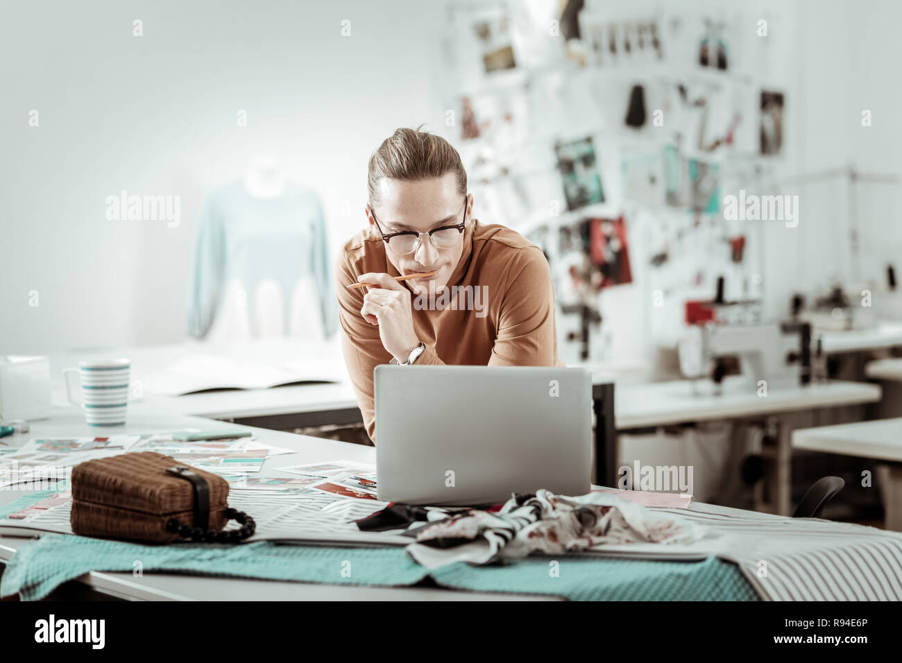 Young long-haired designer from a fashion school working on a new ...