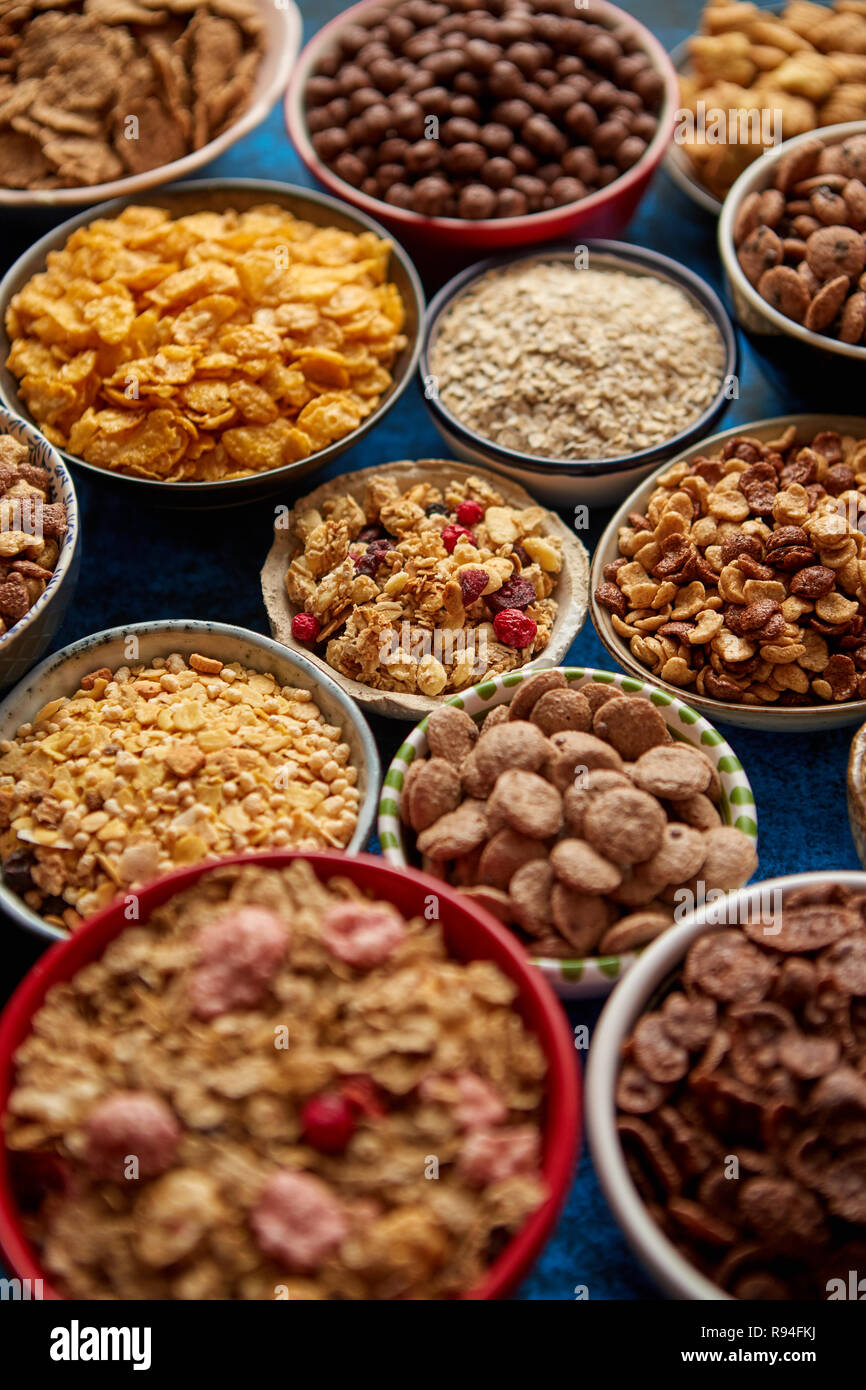 Assortment of different kinds cereals placed in ceramic bowls on table ...