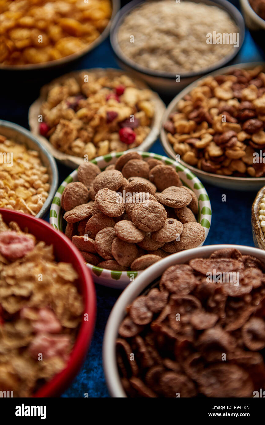 Assortment of different kinds cereals placed in ceramic bowls on table ...