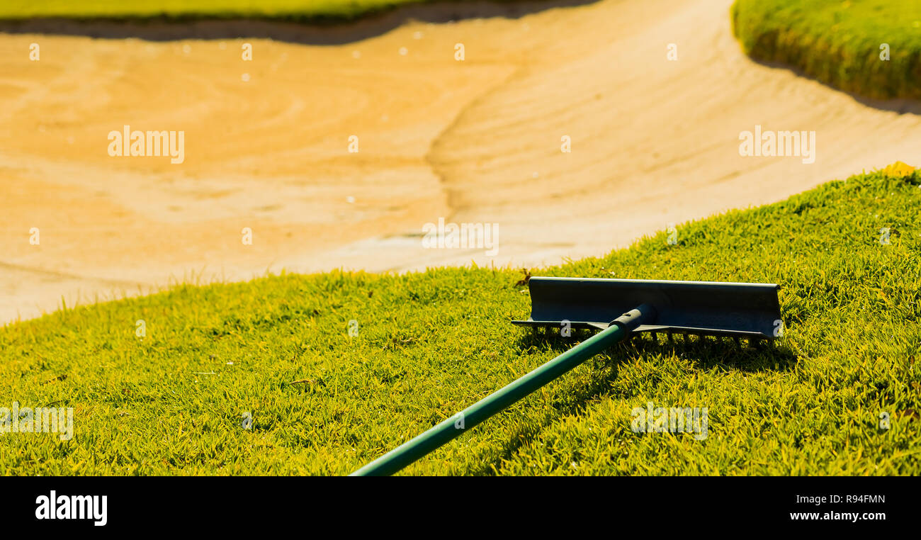 Sand Bunker Hazard and rake on Golf Course Fairway in afternoon light ...