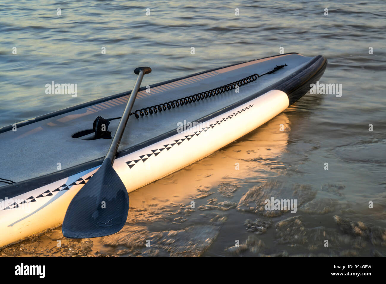 winter paddling - stand up paddleboard with a paddle and safety leash ...