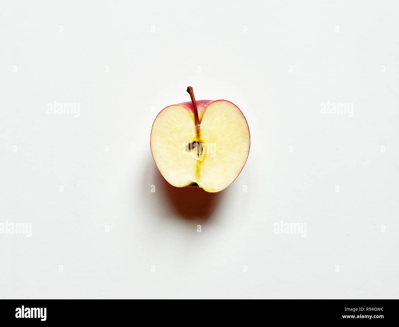 Apple fruit sliced by half isolated in studio over a bright white ...