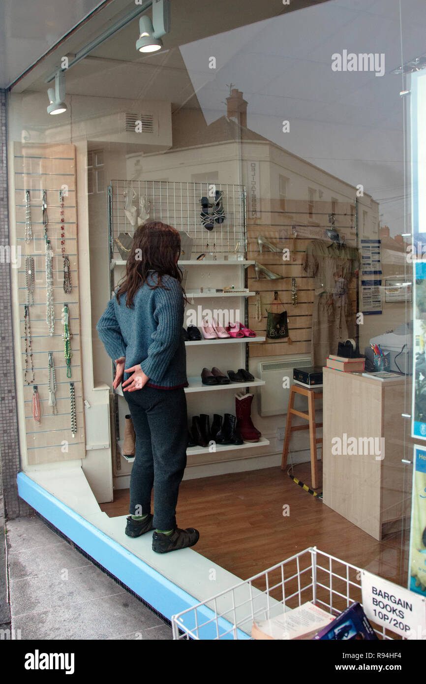 UK High street shoppers shopping and visitors browsing shop fronts ...