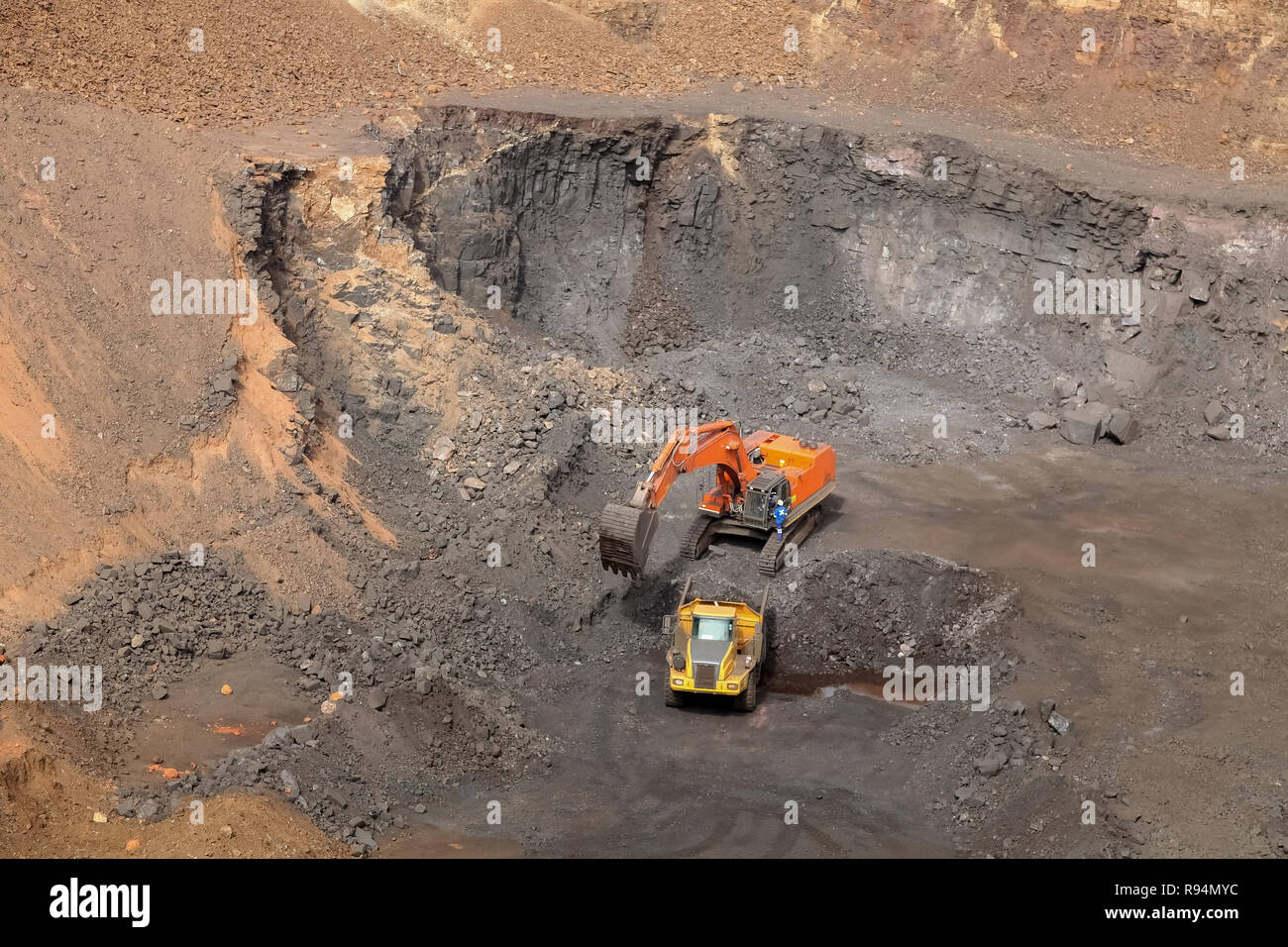 Open pit Manganese Mining - Excavator digging out ore rich rock and ...