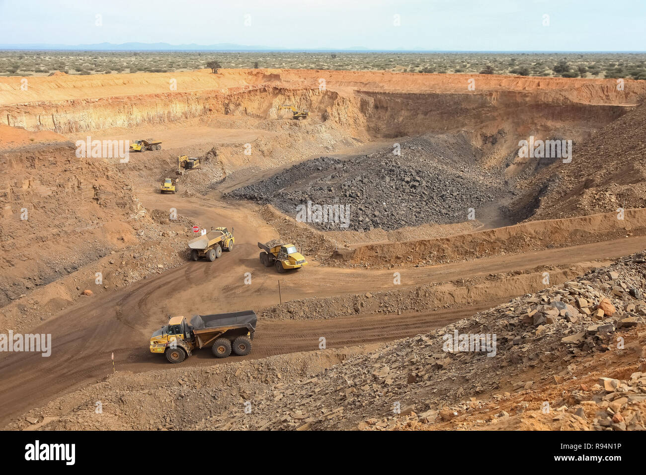 Open pit Manganese Mining - Excavator digging out ore rich rock and ...