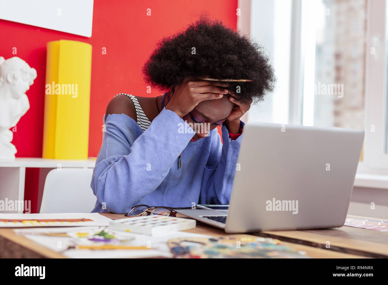 Fashion designer clutching her head while feeling extremely tired Stock ...