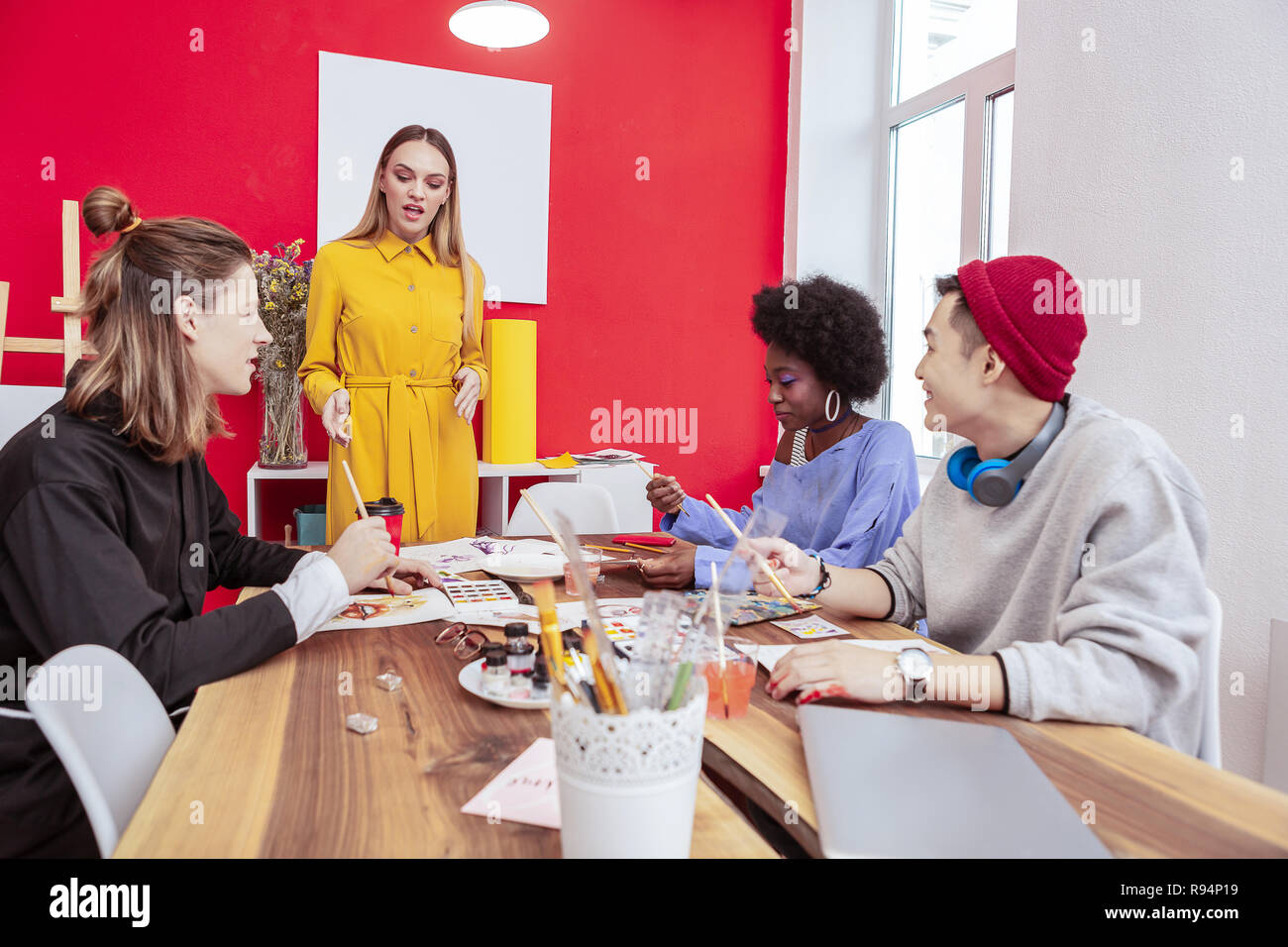 Three promising designers listening to manager of fashion department ...