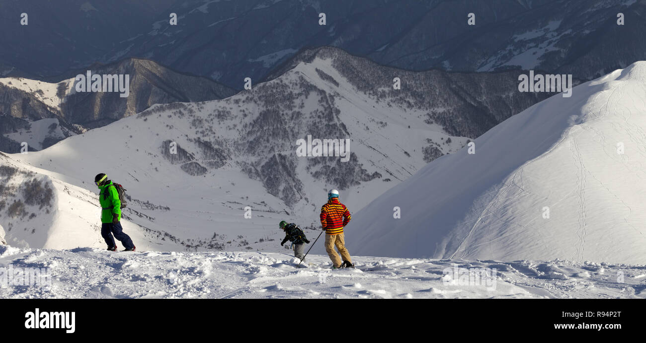 Panoramic view on snowy off-piste slope with skier and snowboarders at ...