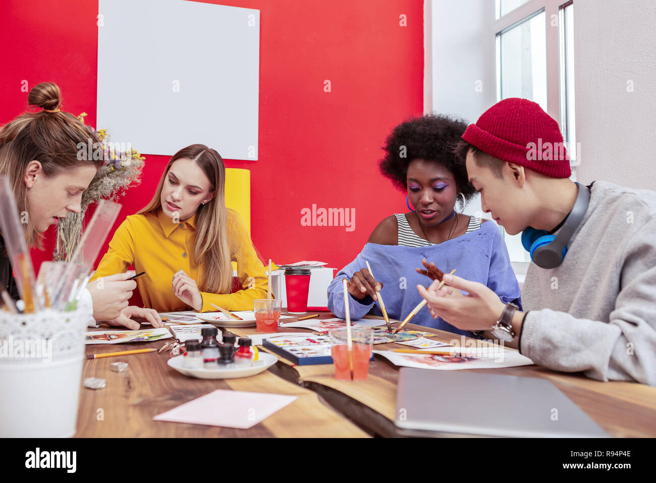 Two creative talented couples feeling joyful while drawing Stock Photo ...