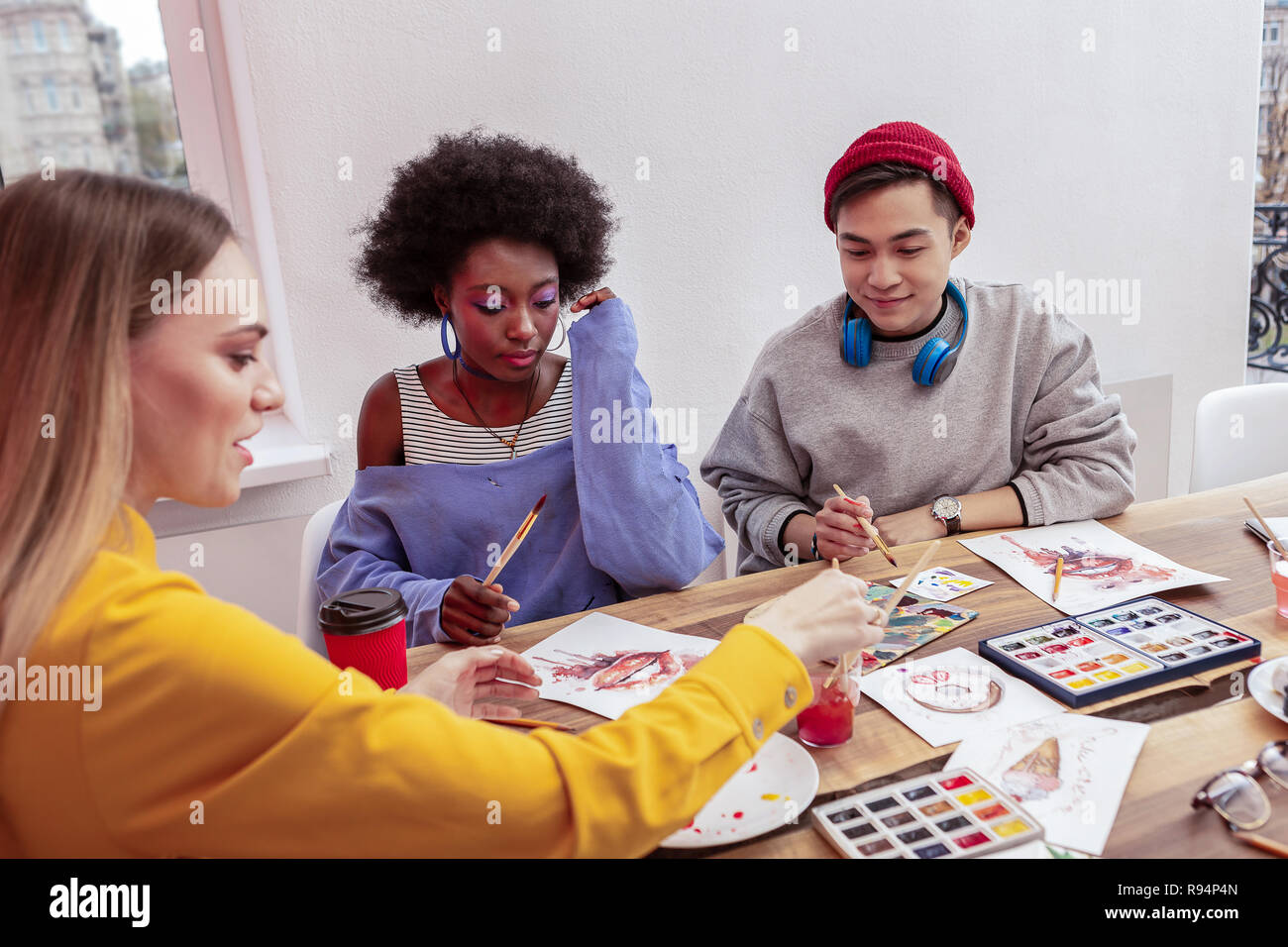 Teacher showing some painting techniques to her students Stock Photo ...
