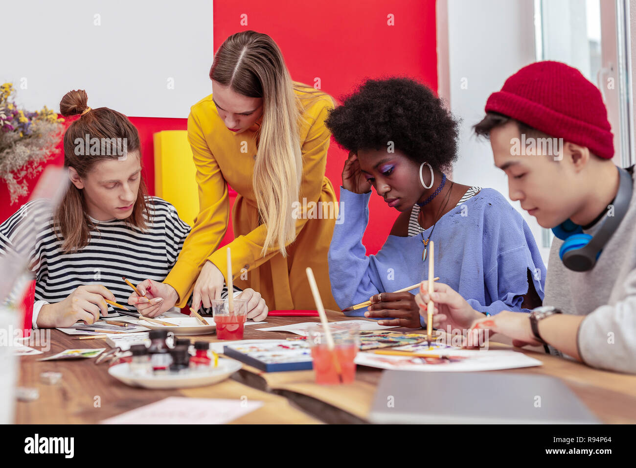 Helpful teacher assisting her art students in the process of work Stock ...