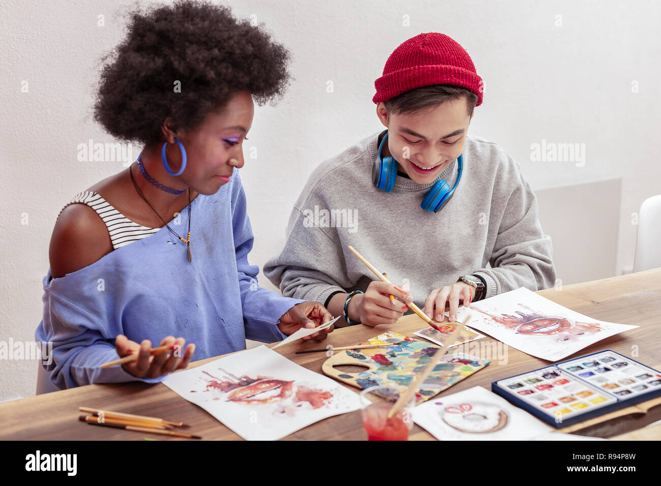 Couple of art students mixing colors while drawing together Stock Photo ...