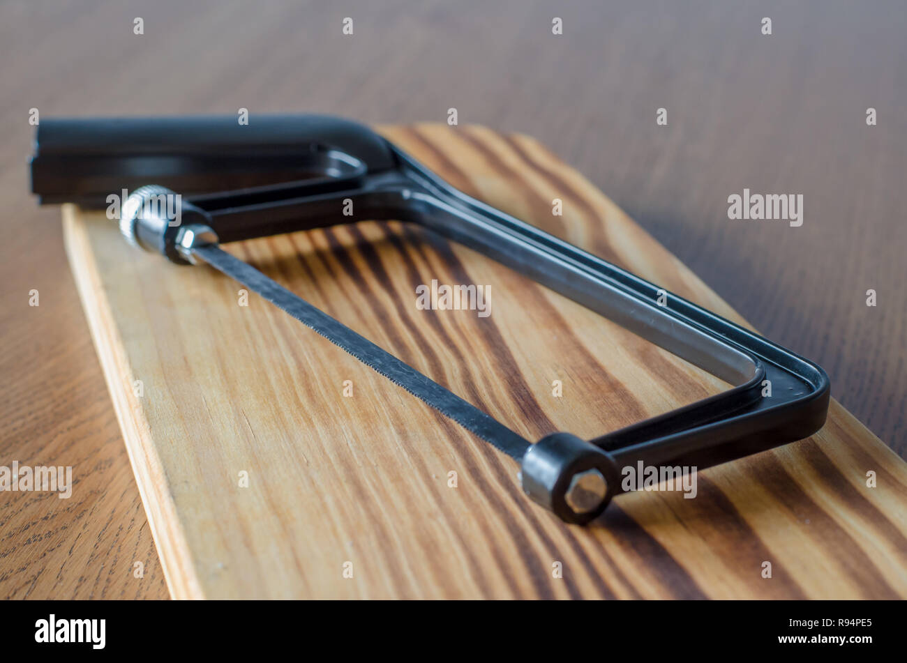 Black hand Saw on the wooden background. Close-up Stock Photo - Alamy