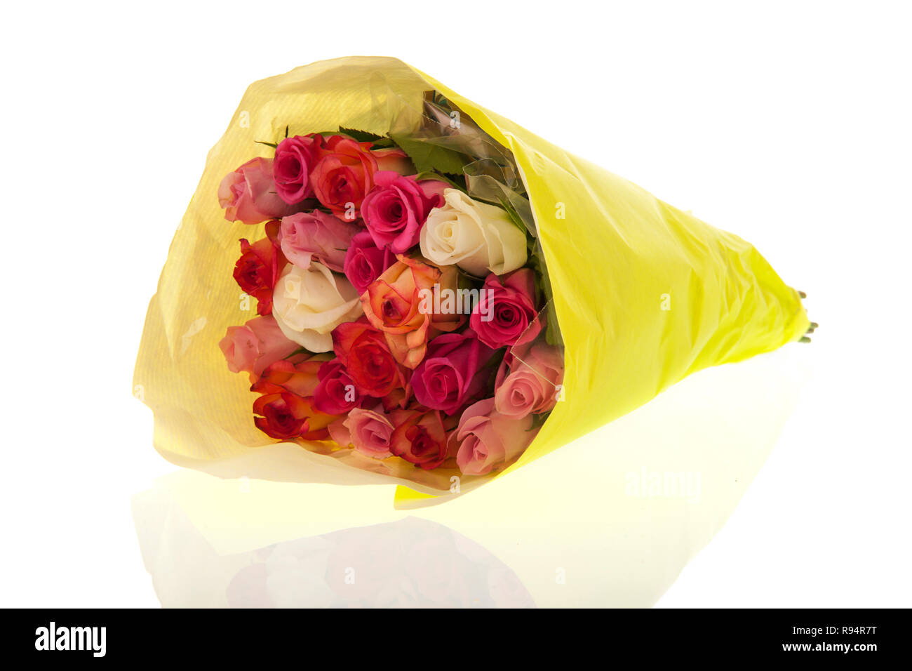 Bouquet colorful mixed roses wrapped in yellow paper isolated over ...