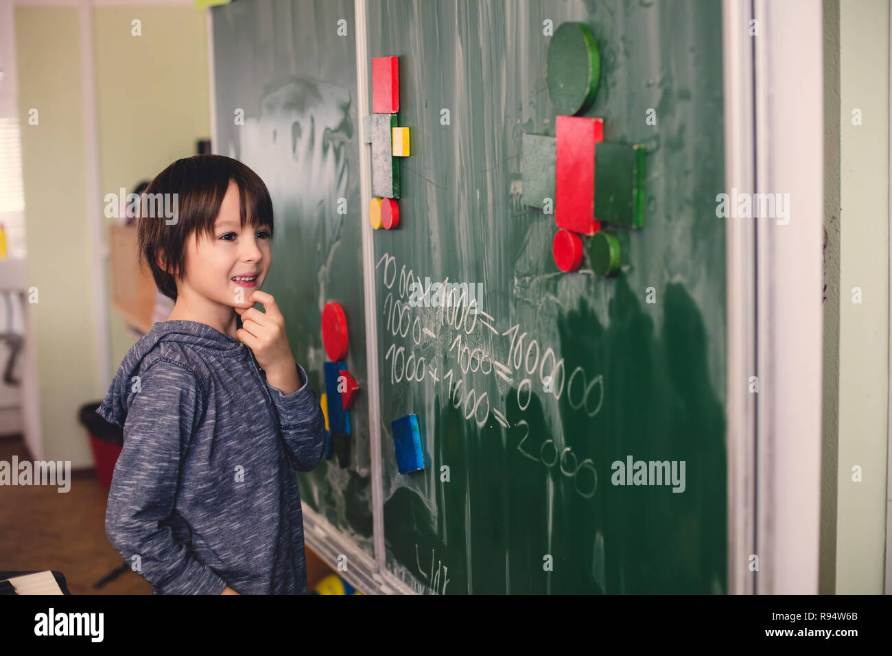 First grade child, learning math, shapes and colors at school, standing ...