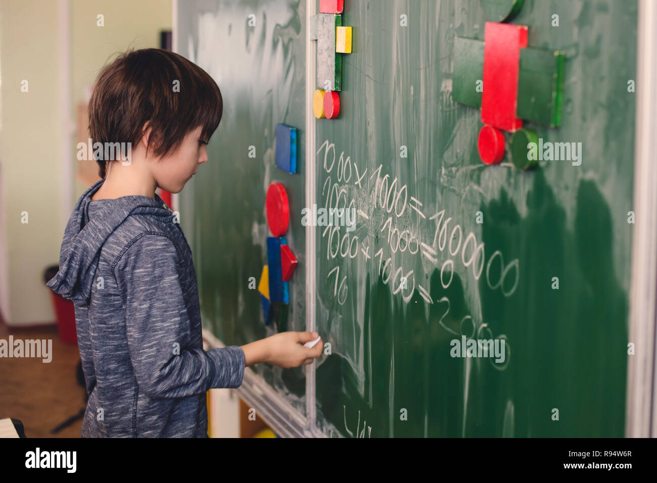 First grade child, learning math, shapes and colors at school, standing ...