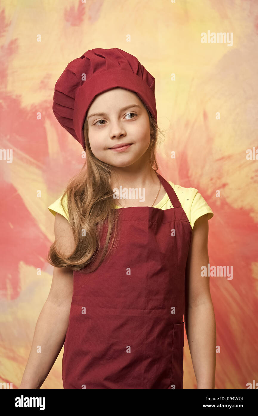 small baby girl or cute child with happy face in red chef hat and cook ...