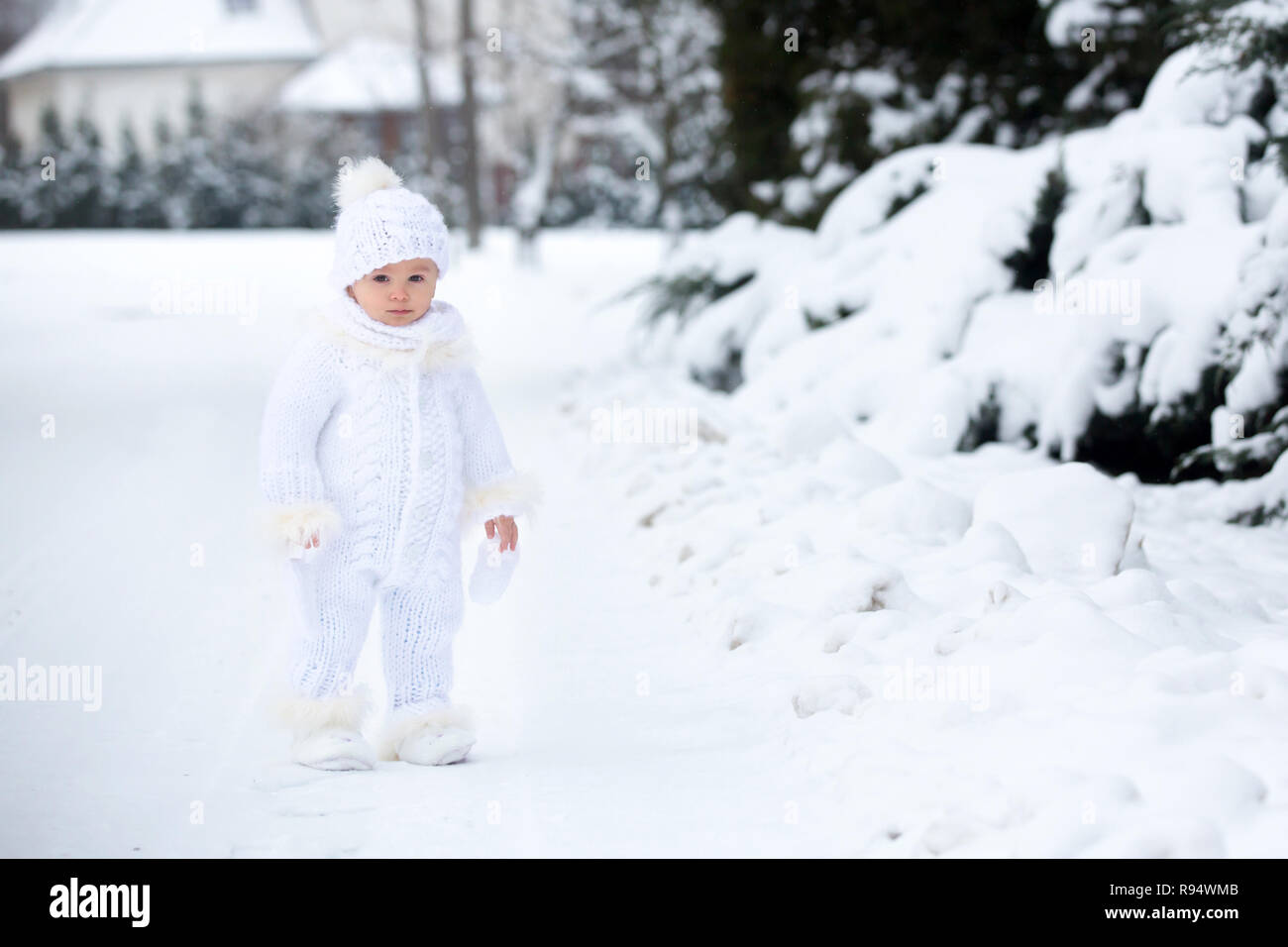 Cute little toddler boy, playing outdoors with snow on a winter day ...