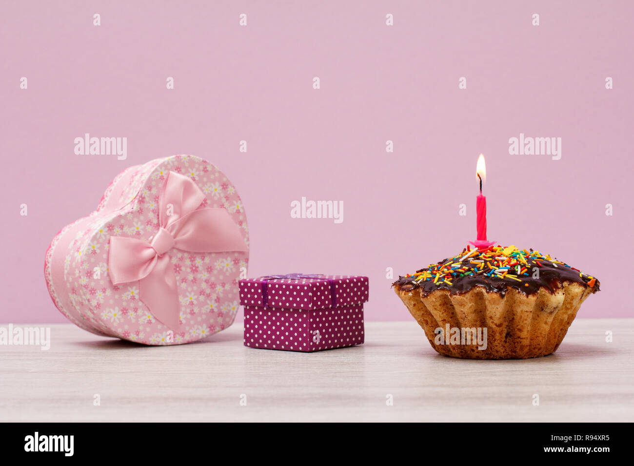 Gift boxes and tasty birthday muffin with chocolate glaze and caramel ...