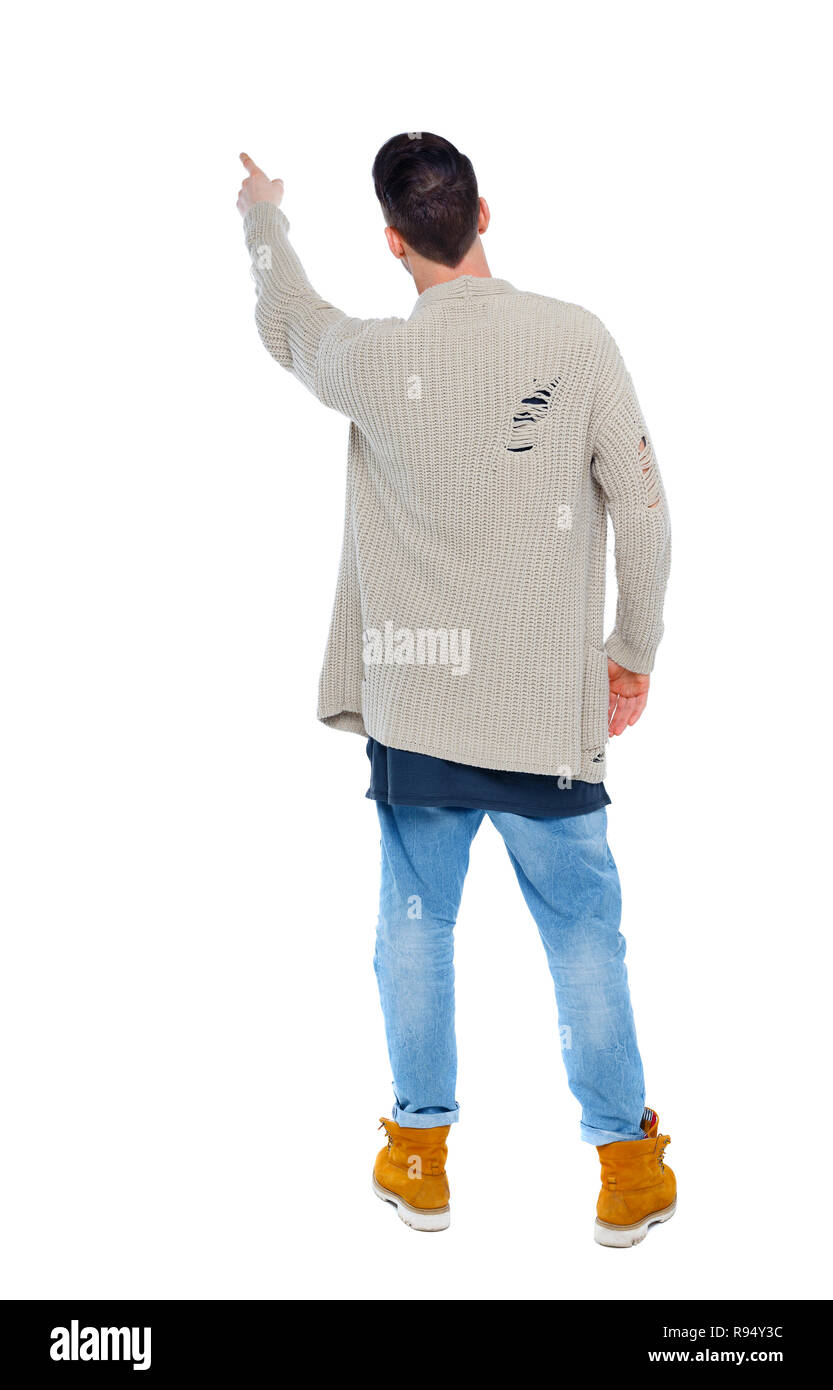 Back view of a stylish man in a knitted sweater points his hand upwards ...