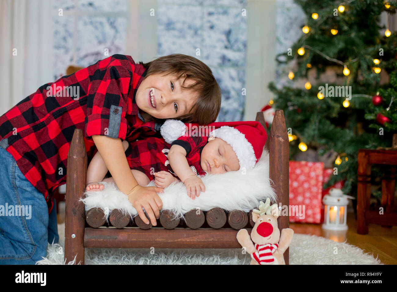 Portrait of newborn baby and his brother in Santa clothes, sleeping in ...