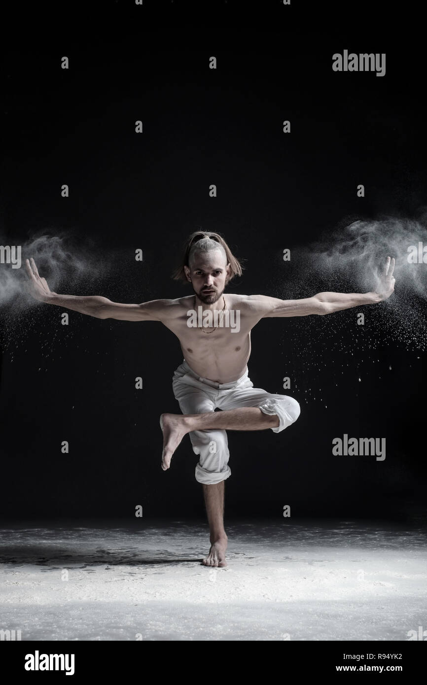 Sporty young man practicing yoga, doing balance exercise on leg ...